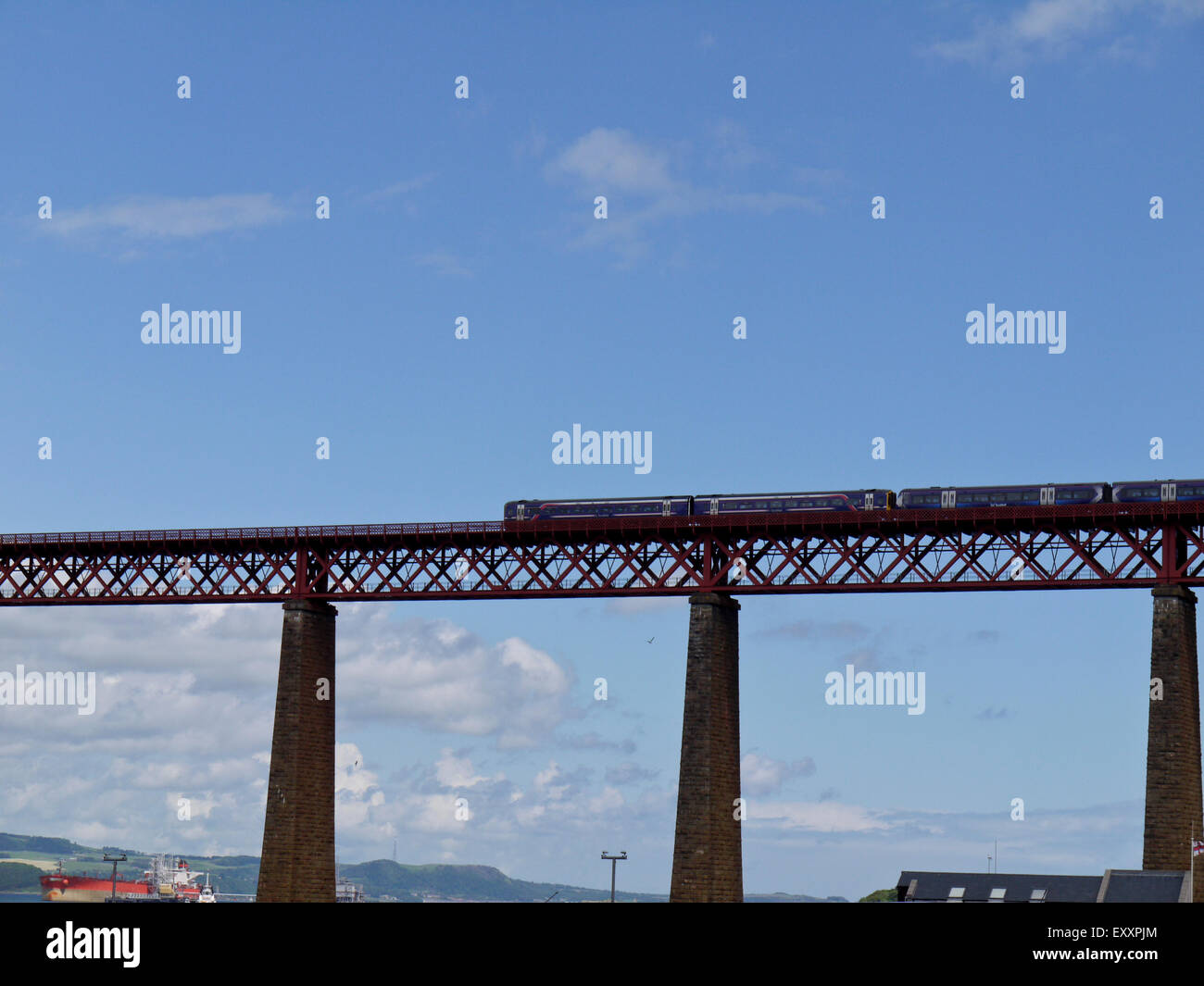 Commuter train going over The Firth Of Forth rail bridge, Edinburgh ...