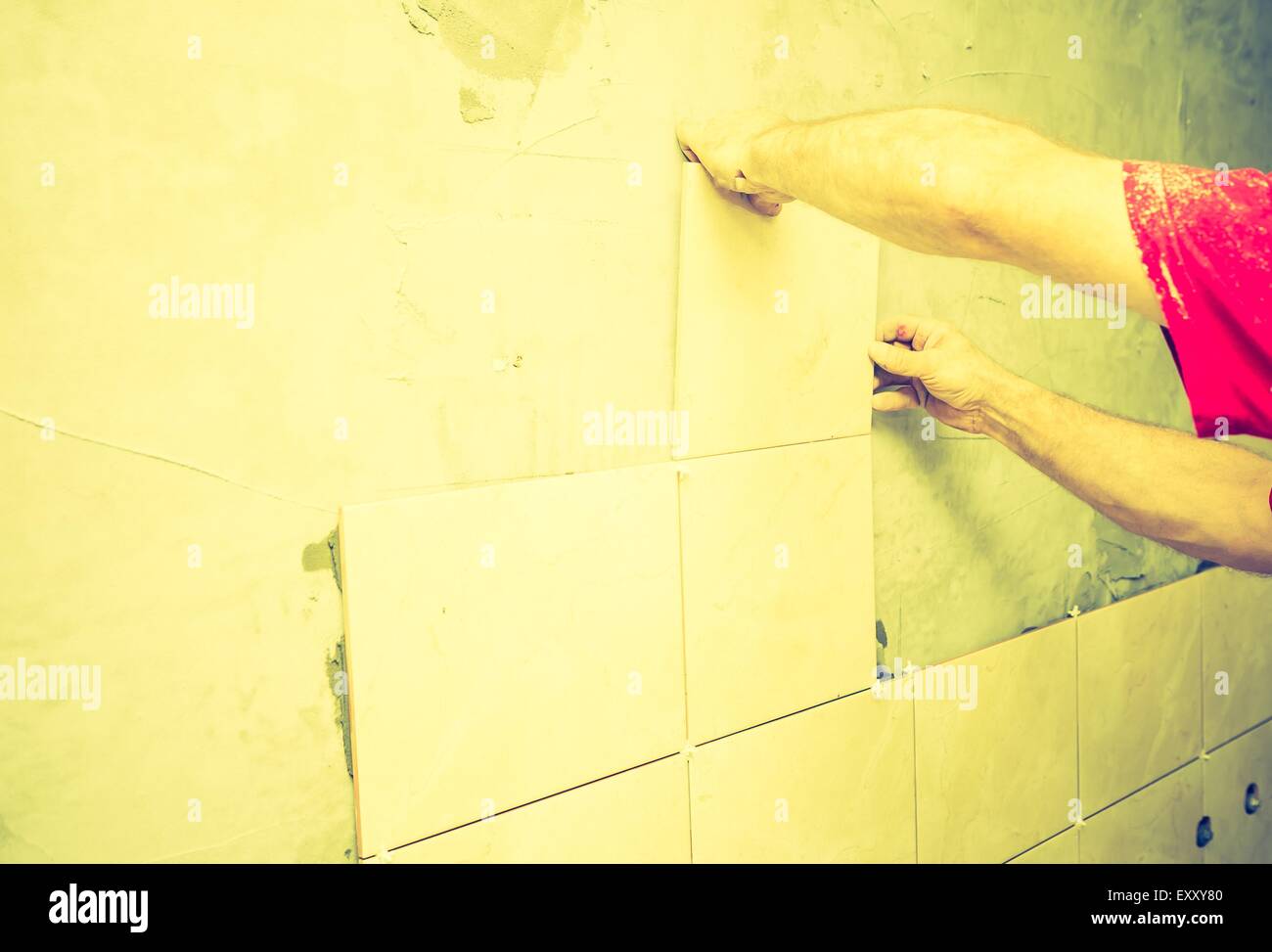 Vintage photo of construction mason man hands on tiles work with cement ...