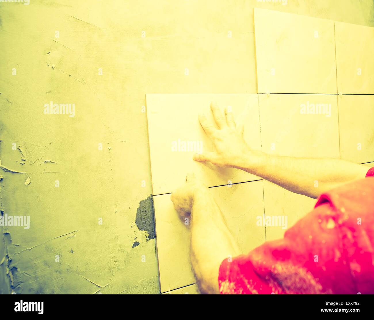 Vintage photo of construction mason man hands on tiles work with cement ...