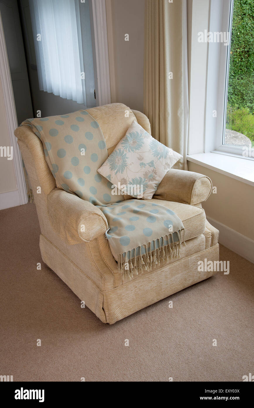 A comfortable easy chair with cushion and shawl Stock Photo - Alamy