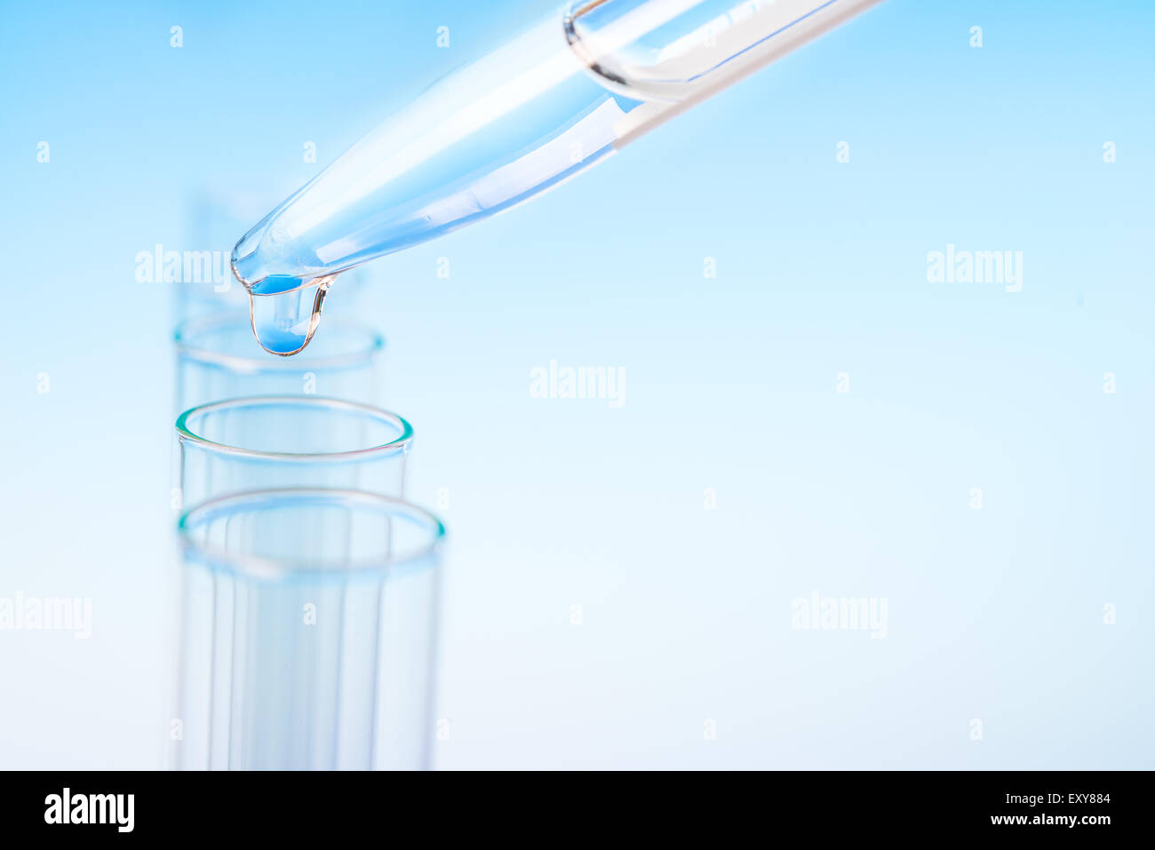 Scientific background: drop from pipette falling in a tube, text space ...