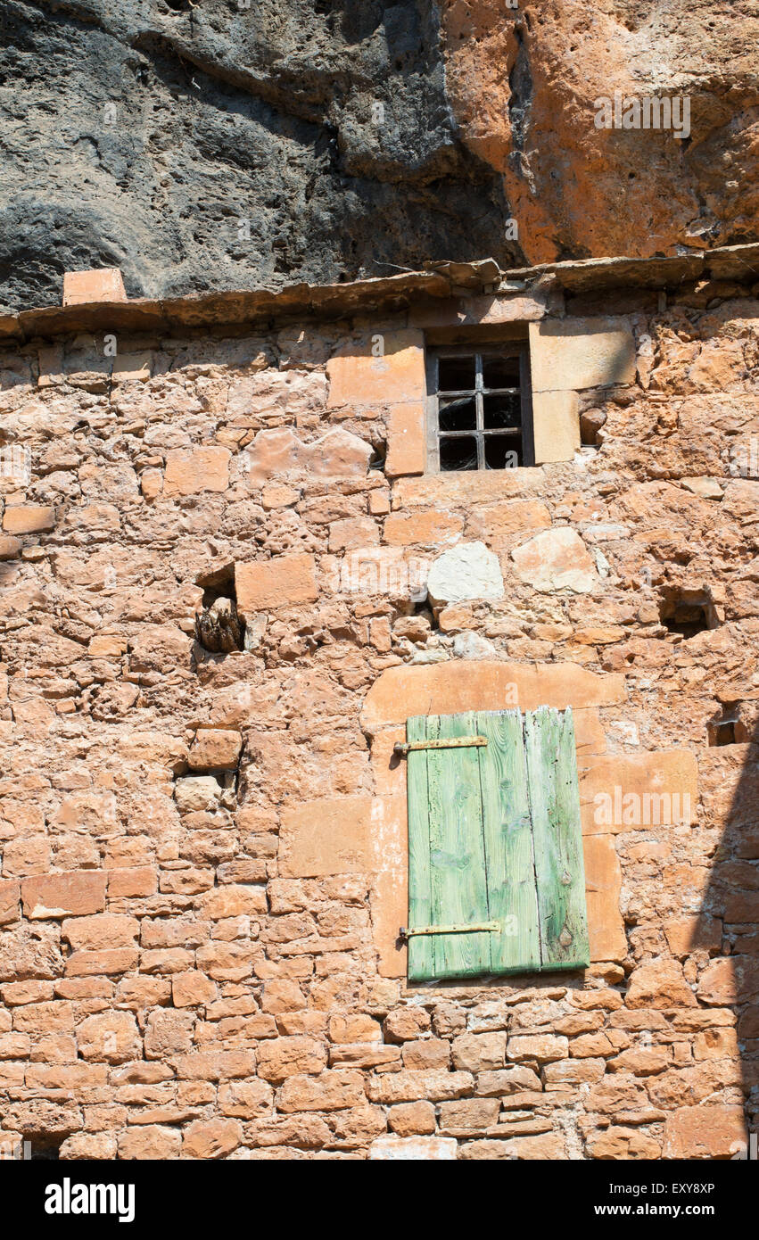 Old stone building with green shutter built into the cliff at the ...