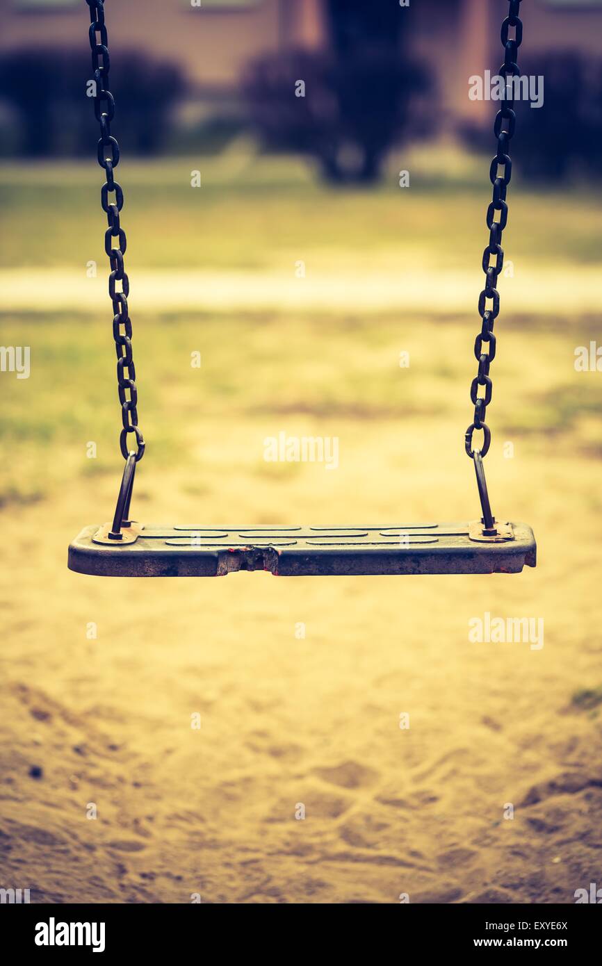 Vintage photo of empty swing on children playground in city. Old ...