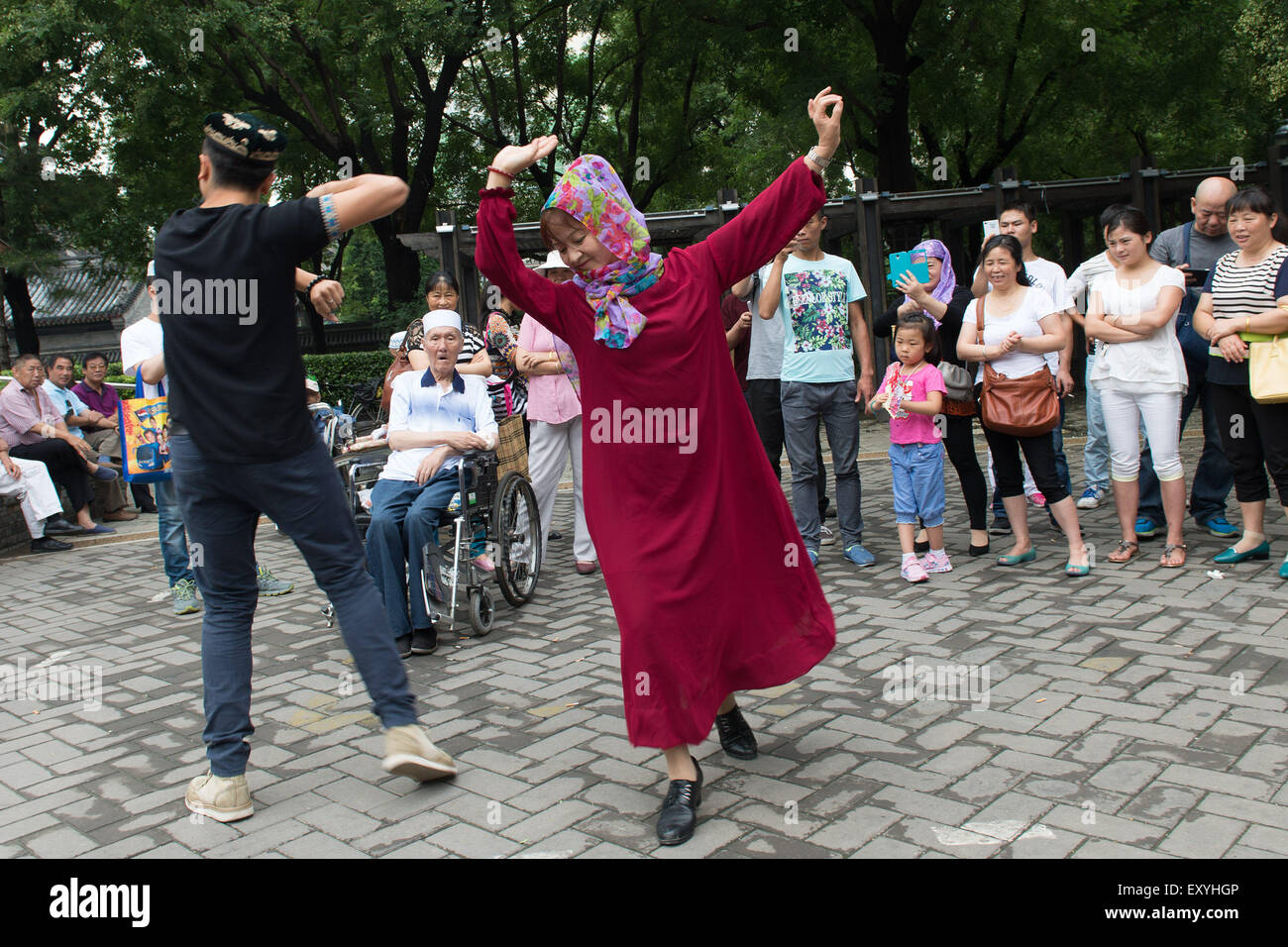 Beijing, China. 18th July, 2015. Muslims dance at the Ox Street in ...