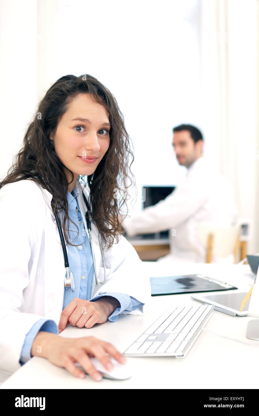 View of a Doctor working at the office with assistant Stock Photo - Alamy