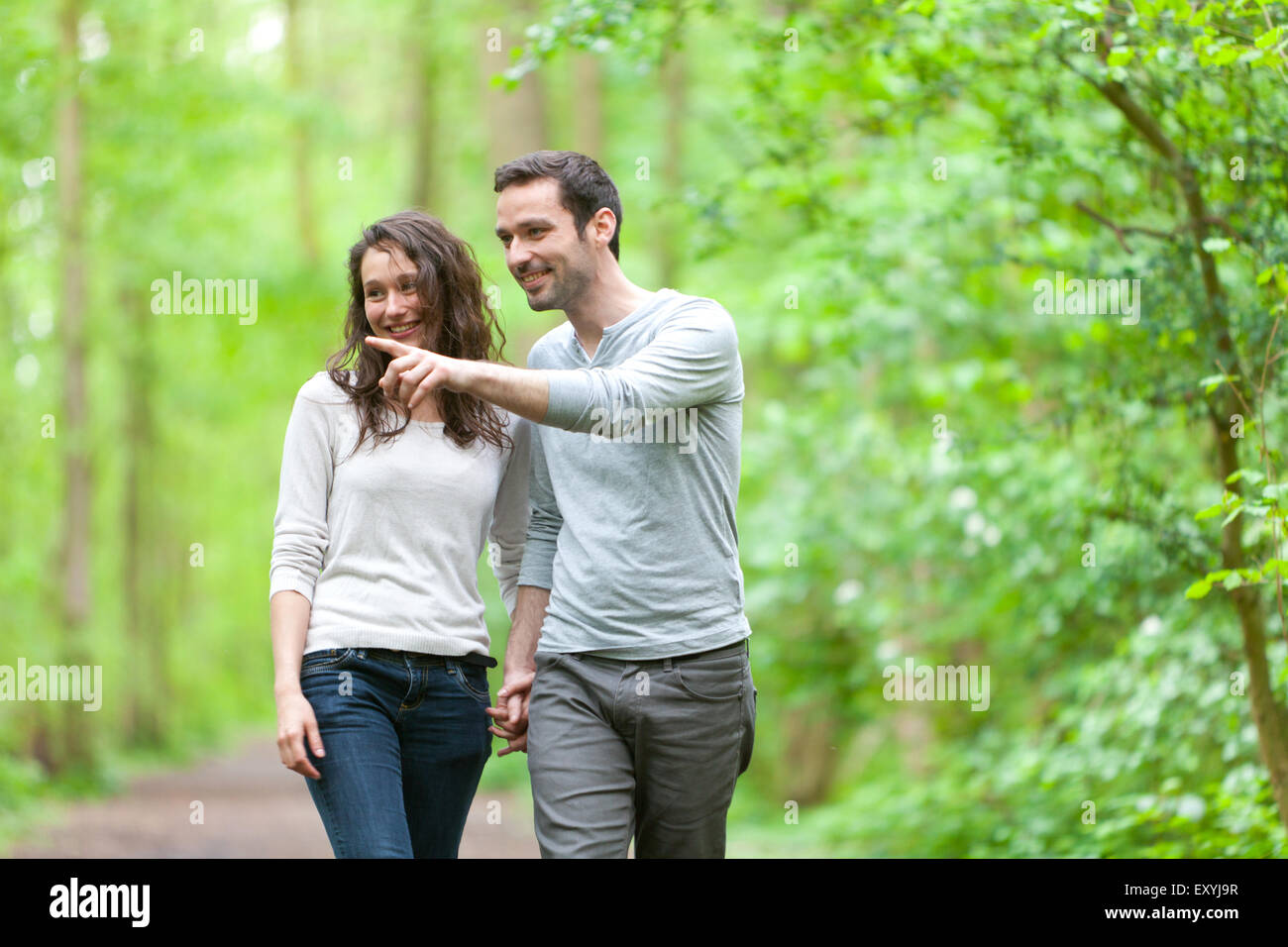 View of a Young couple having a walk in a forest Stock Photo - Alamy