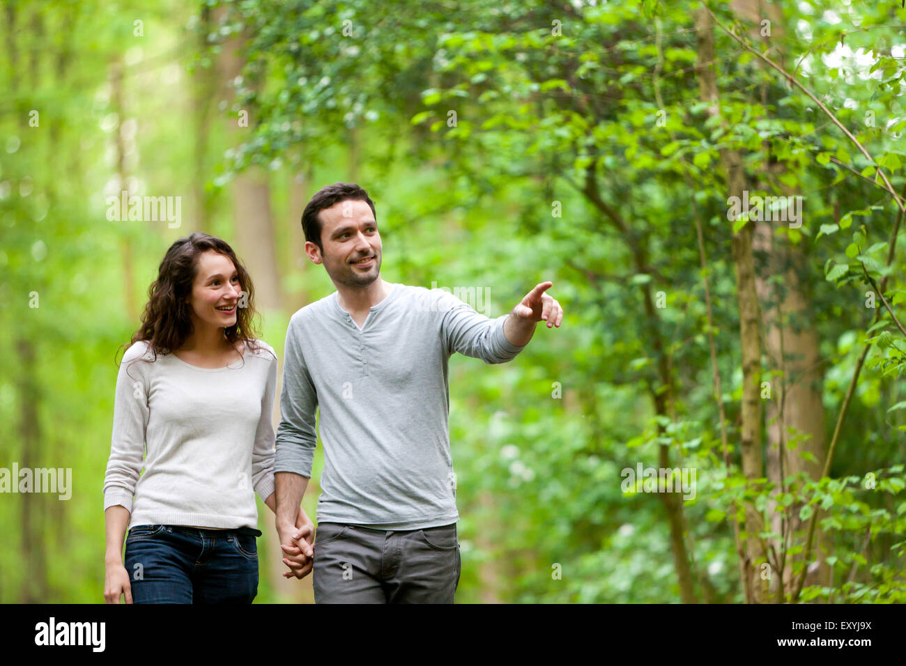 View of a Young couple having a walk in a forest Stock Photo - Alamy
