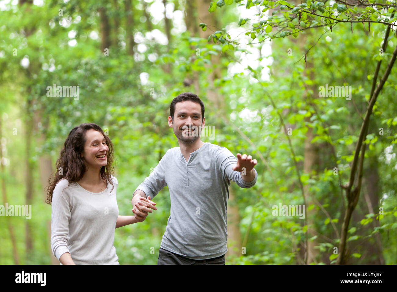 View of a Young couple having a walk in a forest Stock Photo - Alamy