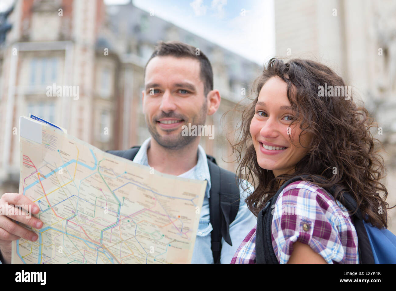 View of a Couple of young attractive tourists watching map Stock Photo ...