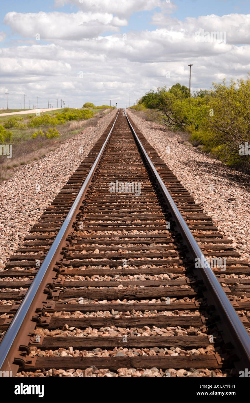 Railroad tracks lead off into the distance under a beautiful Teaxs Sky ...