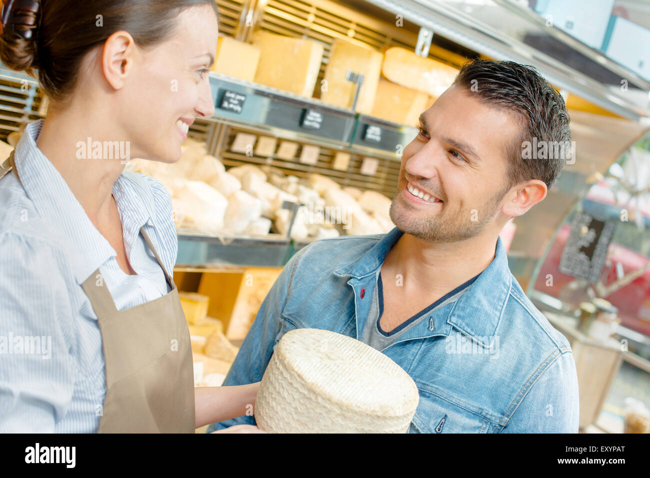 Shop assistant serving cheese Stock Photo - Alamy