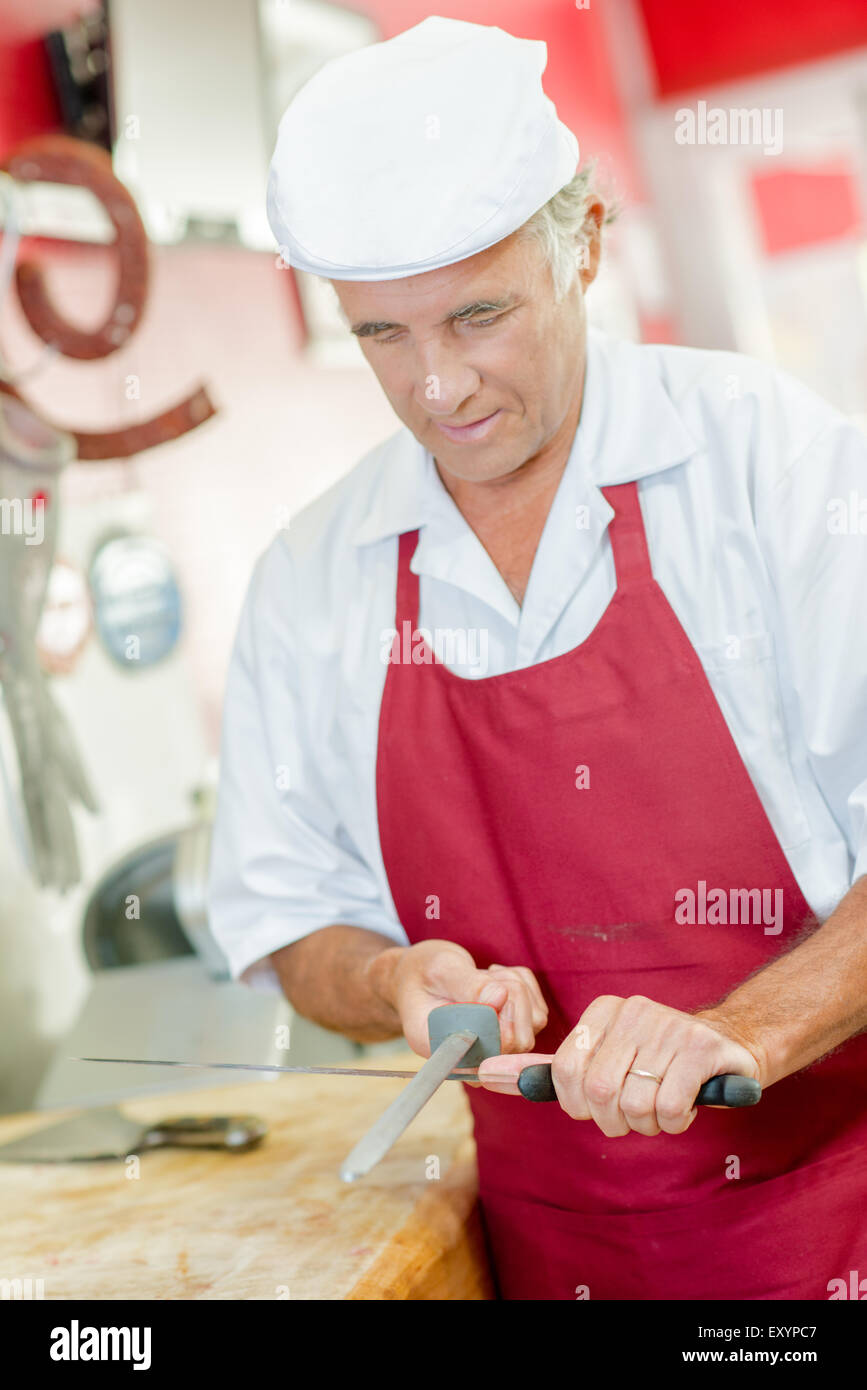 Butcher sharpening a knife Stock Photo - Alamy