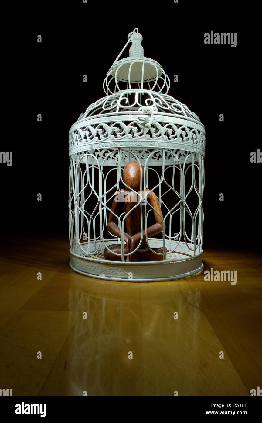 Wooden figurine in a cage Stock Photo - Alamy