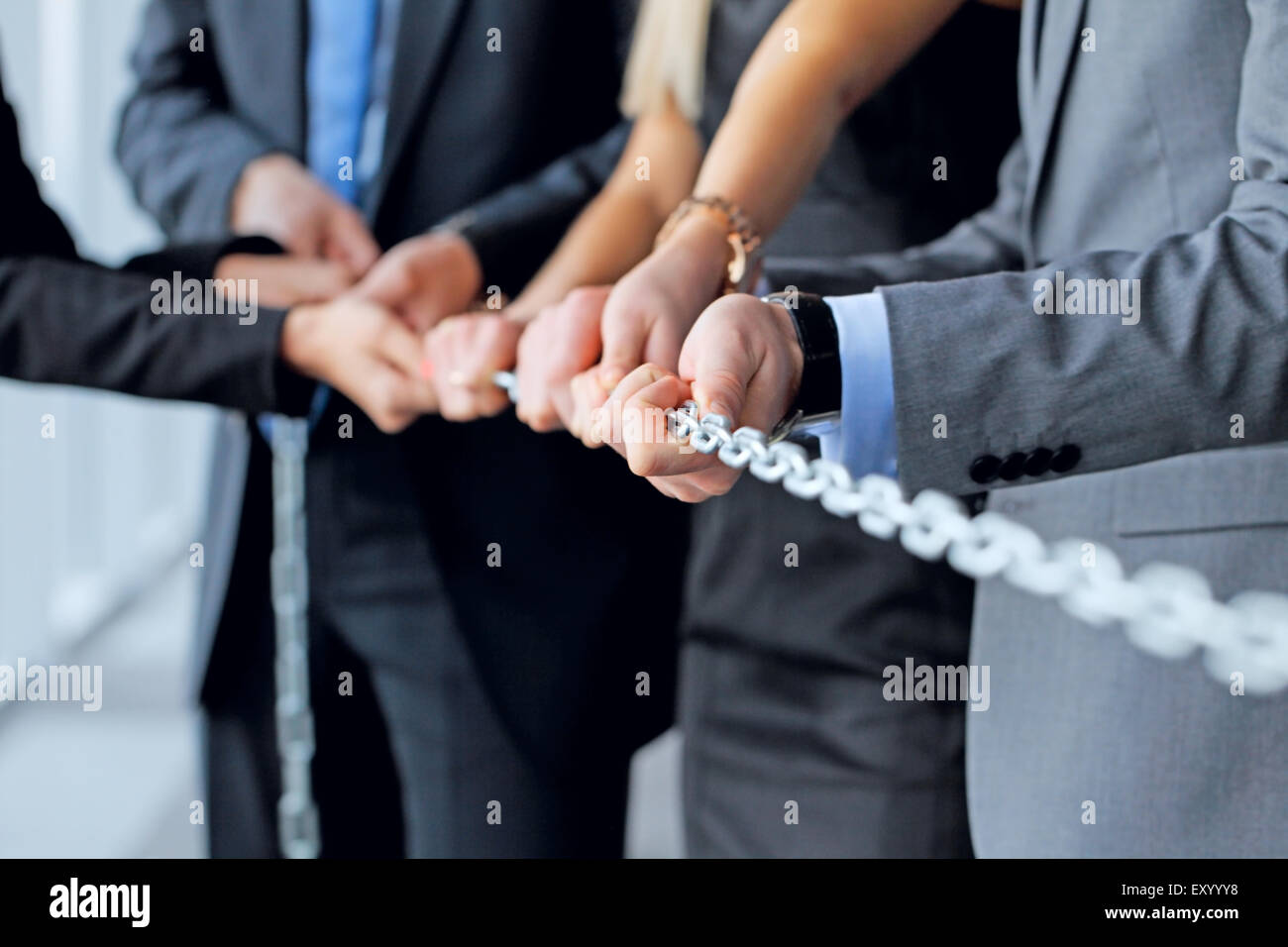 Businessmen pulling chain Stock Photo - Alamy