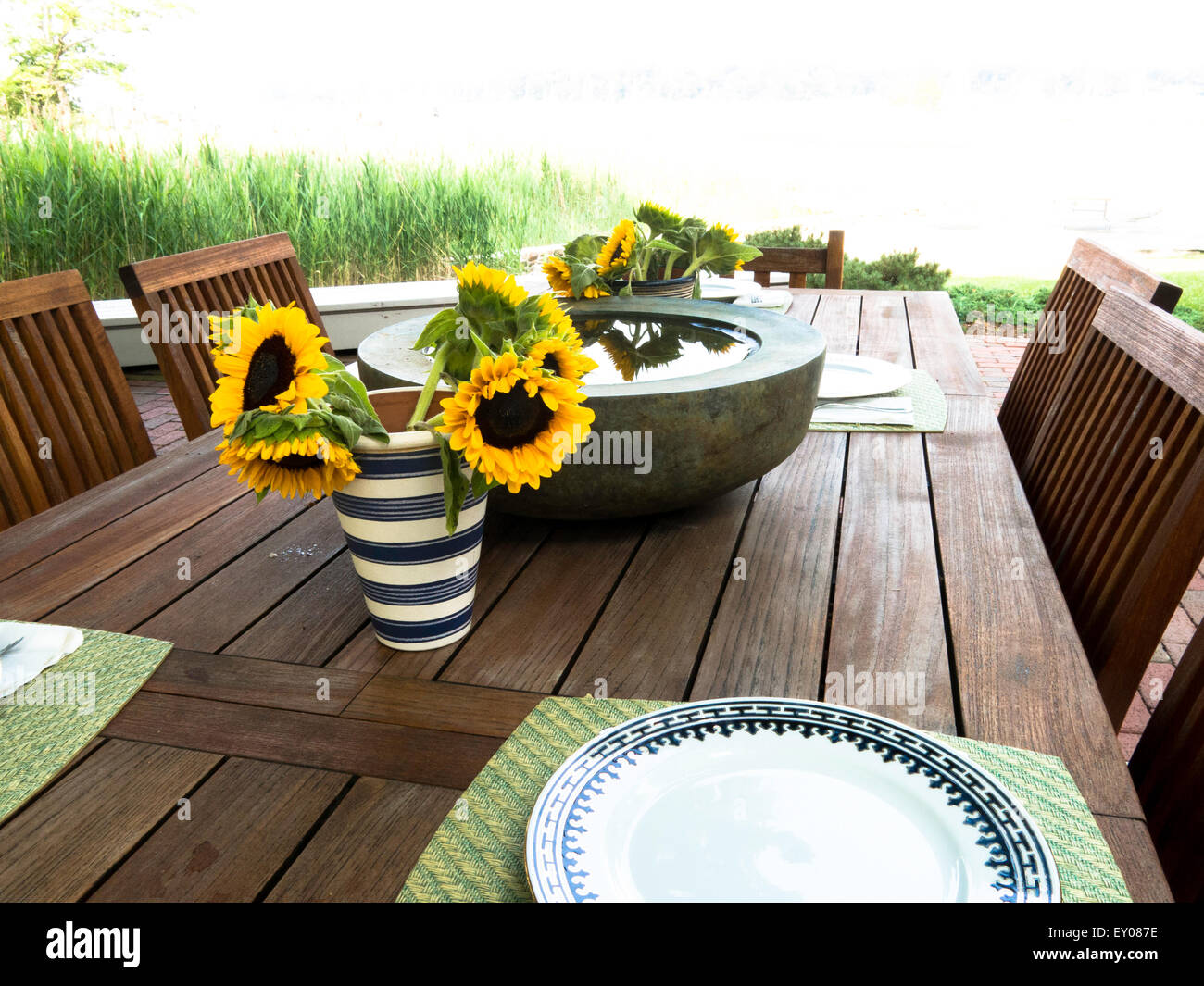 Decorative water cistern and sunflowers on outside patio table, USA ...