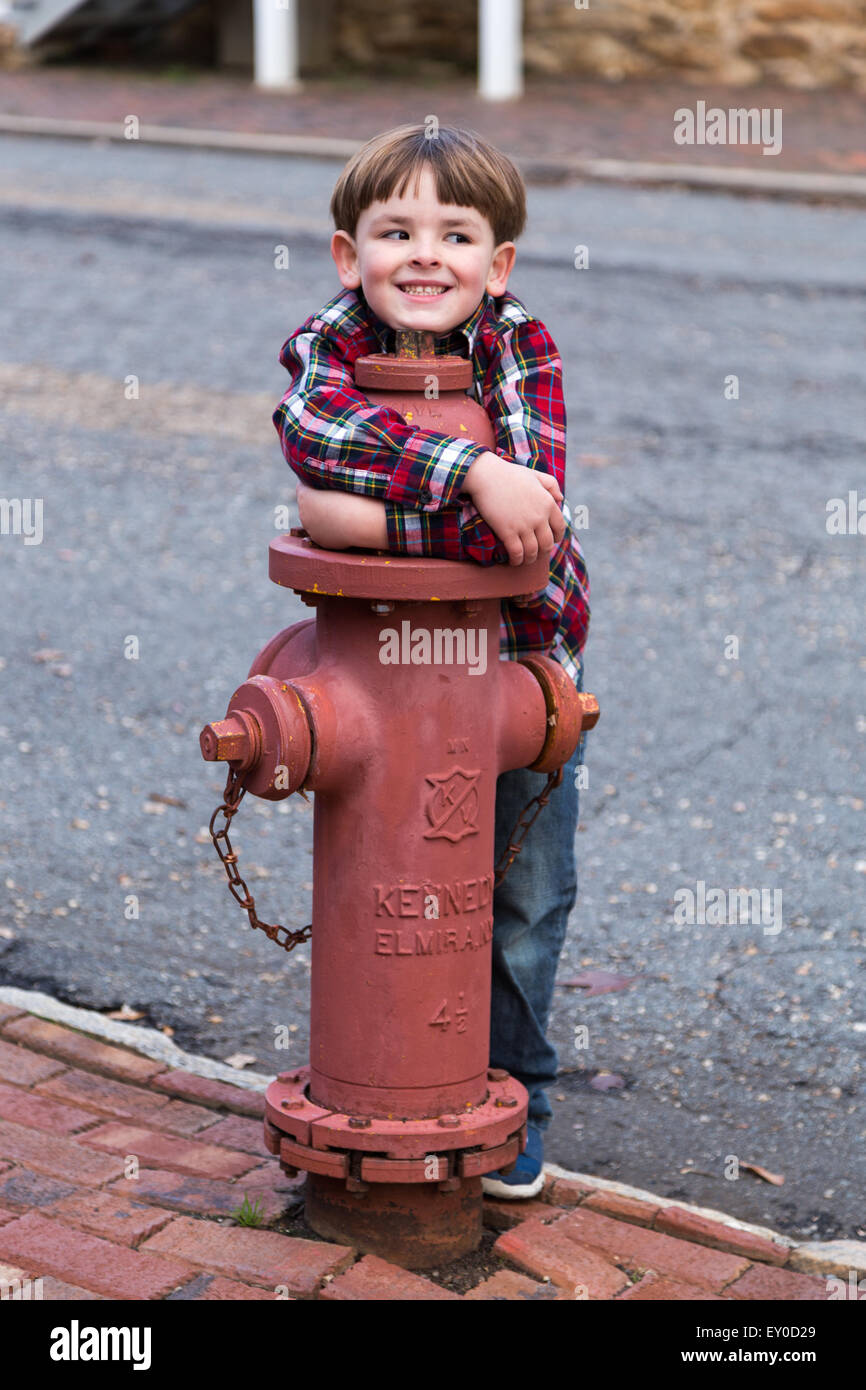 Little boy hugging fire hydrant Stock Photo - Alamy