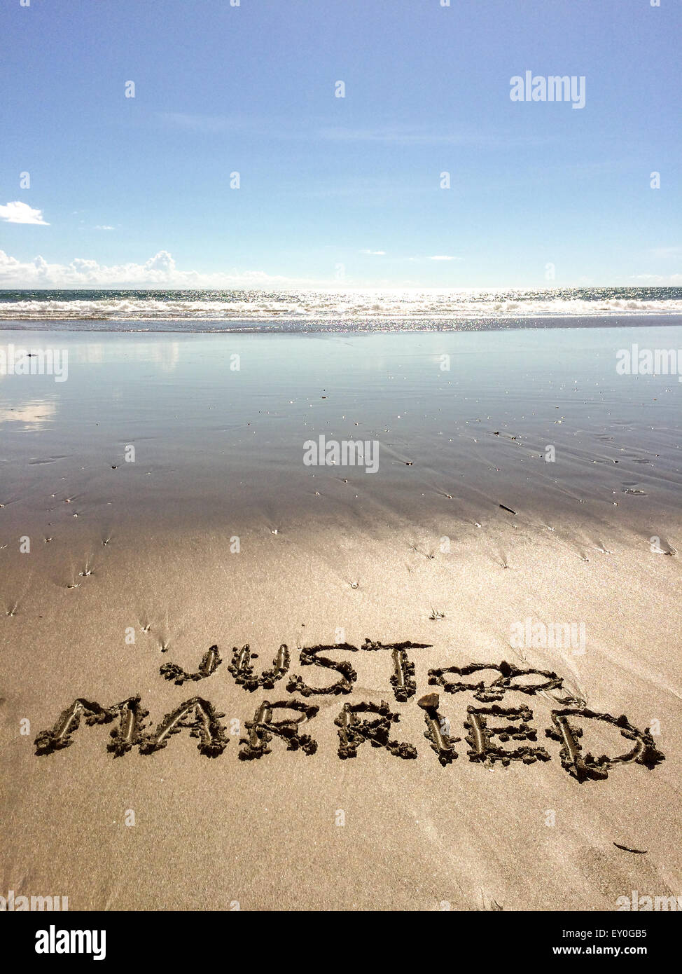 Writing "just married" in the sand on the beach in Bali, Indonesia ...