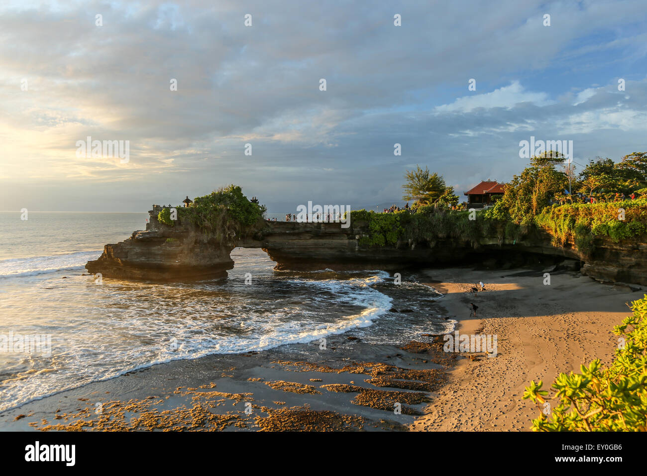 Rock formation with the temple on top of it extending into the ocean in ...