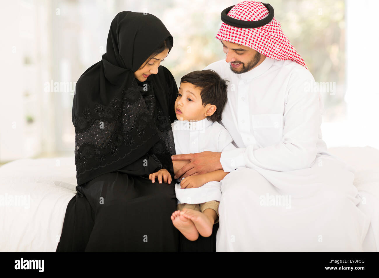 lovely young Muslim family of three sitting at home Stock Photo - Alamy