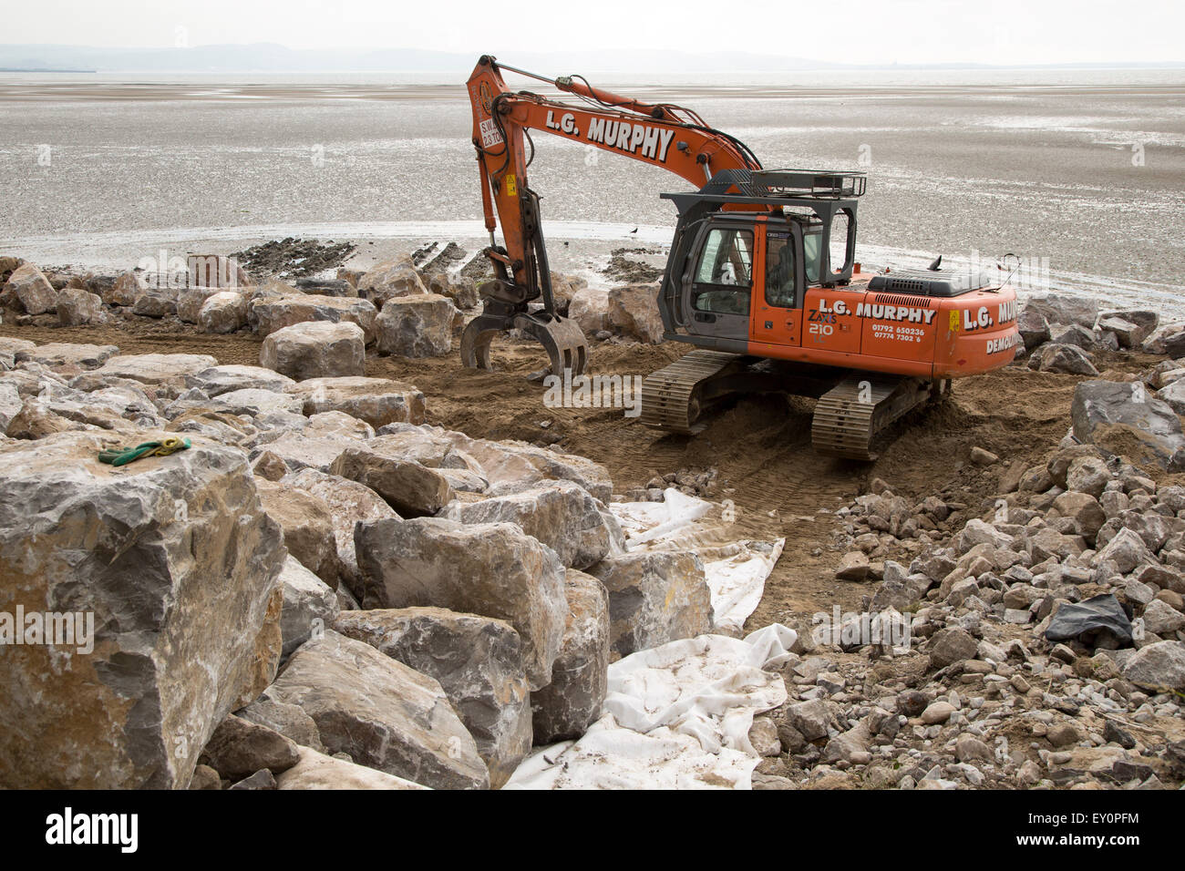 Machinery building rock armour coastal defences at Swansea, West ...