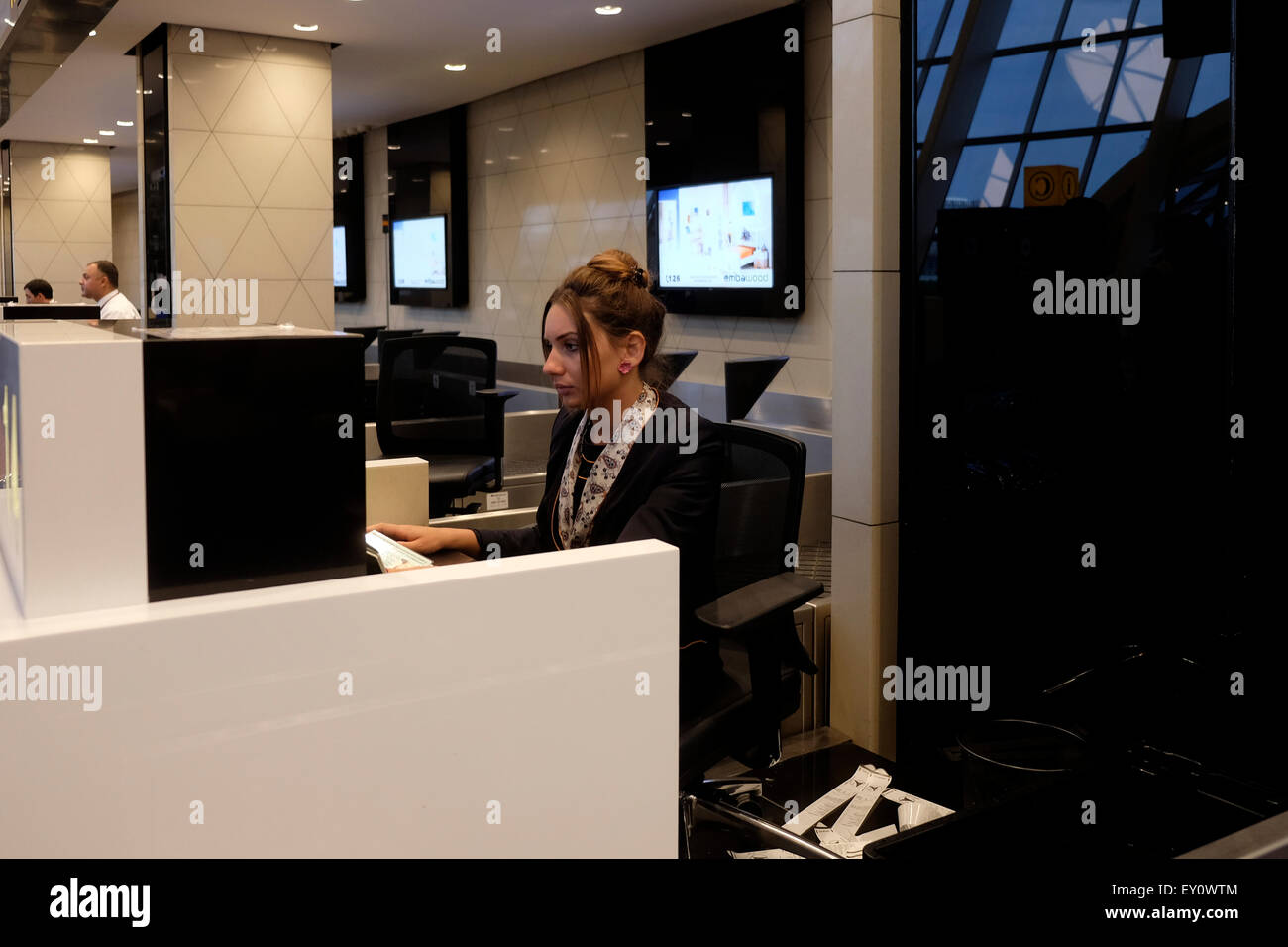 Handling agent works at a check in counter at Heydar Aliyev airport in ...