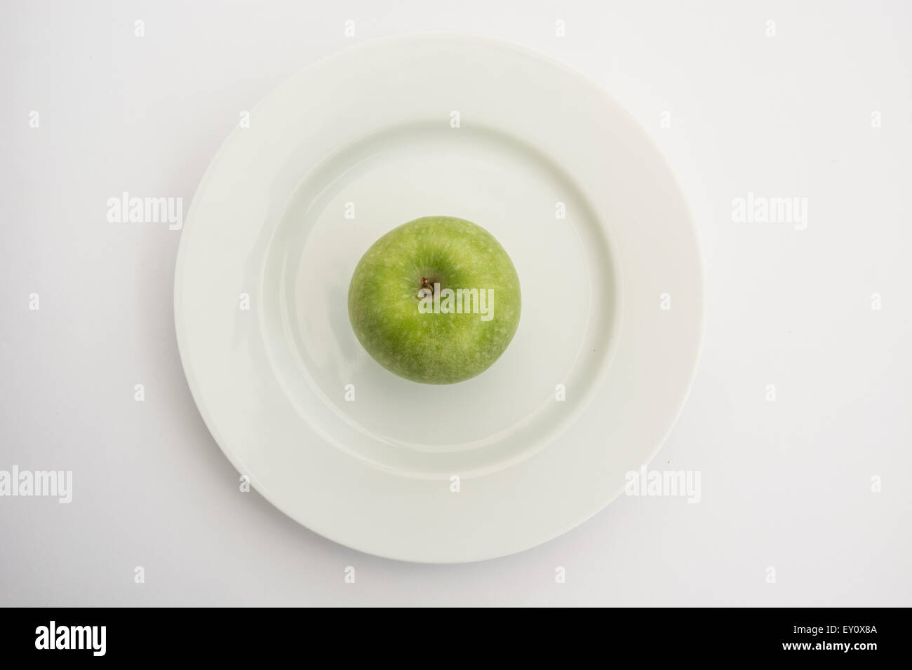 a single apple on a plate Stock Photo - Alamy