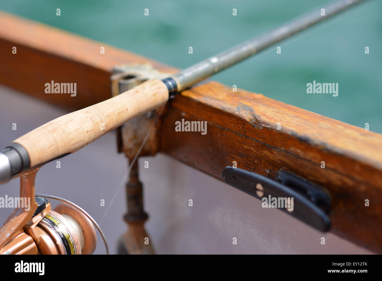 Fishing rod resting on side of boat Stock Photo - Alamy