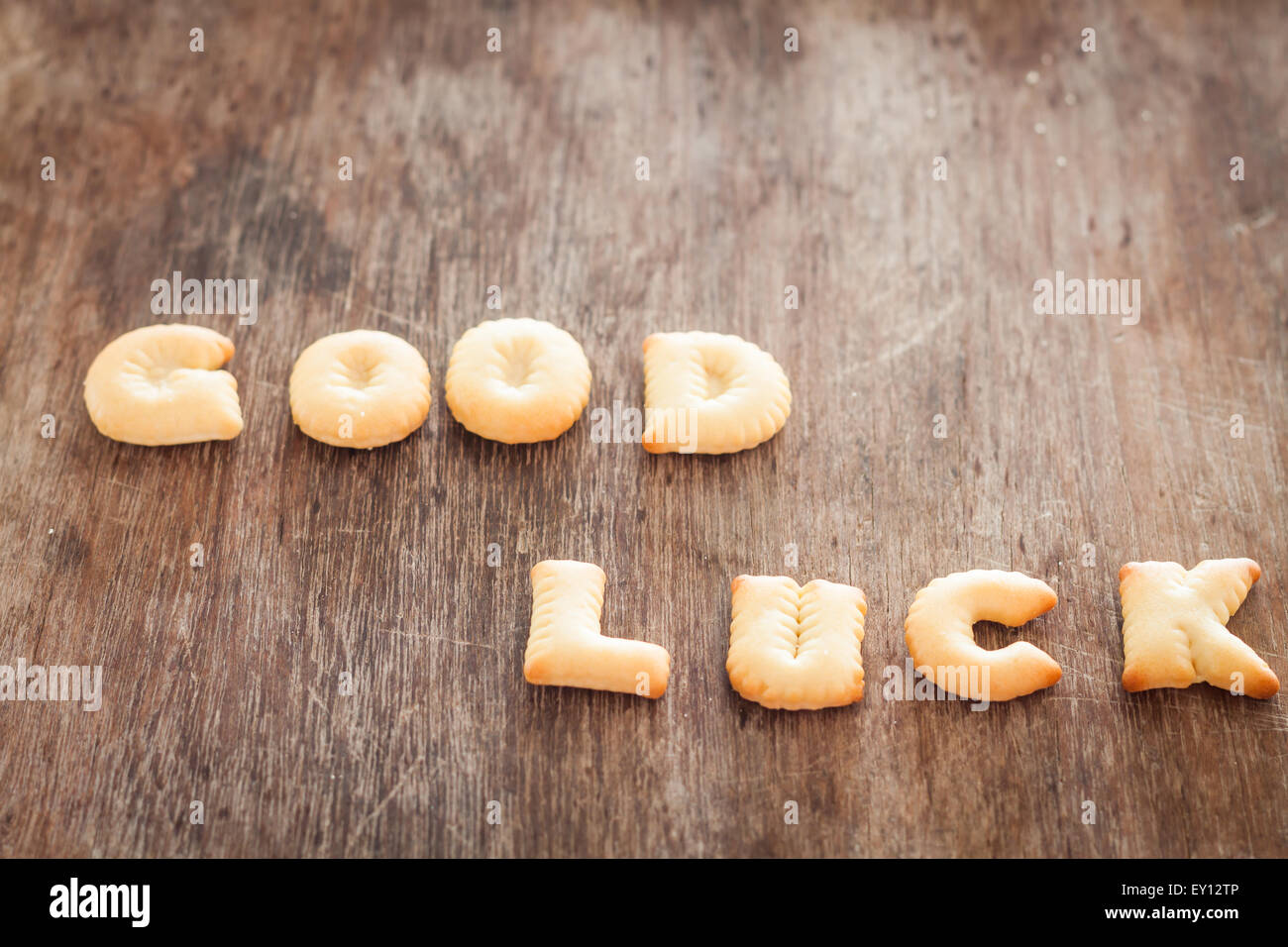 Good luck alphabet biscuit on wooden table, stock photo Stock Photo - Alamy
