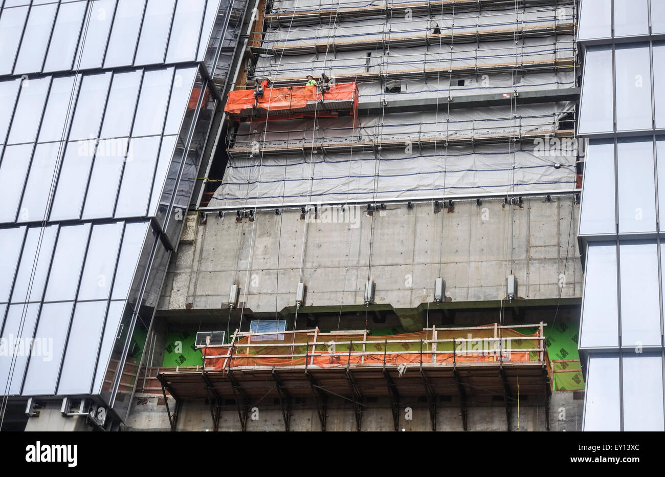 Workers on scaffolding, construction of glass building next to High ...
