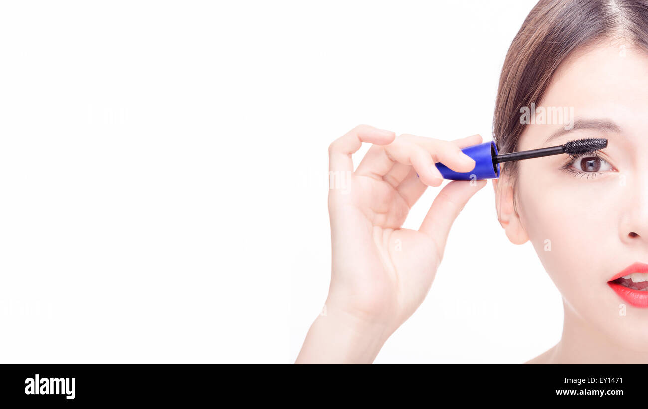 Half of Chinese Asian female face applying mascara, isolated on white ...