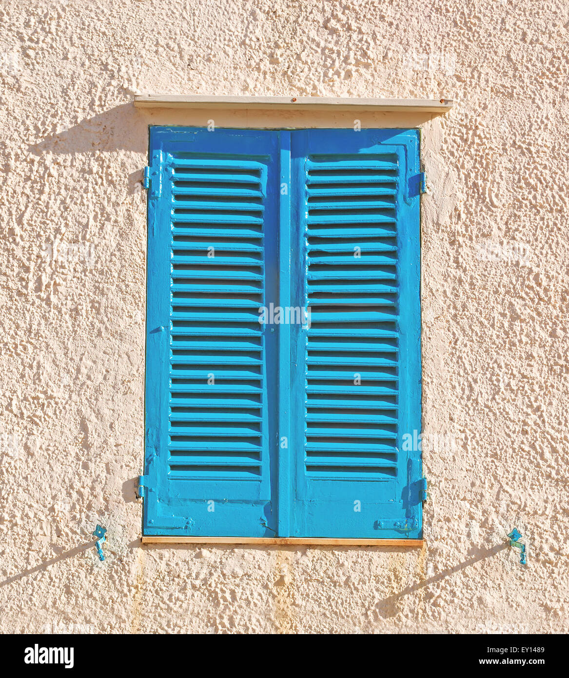 turquoise window in a beige wall Stock Photo - Alamy