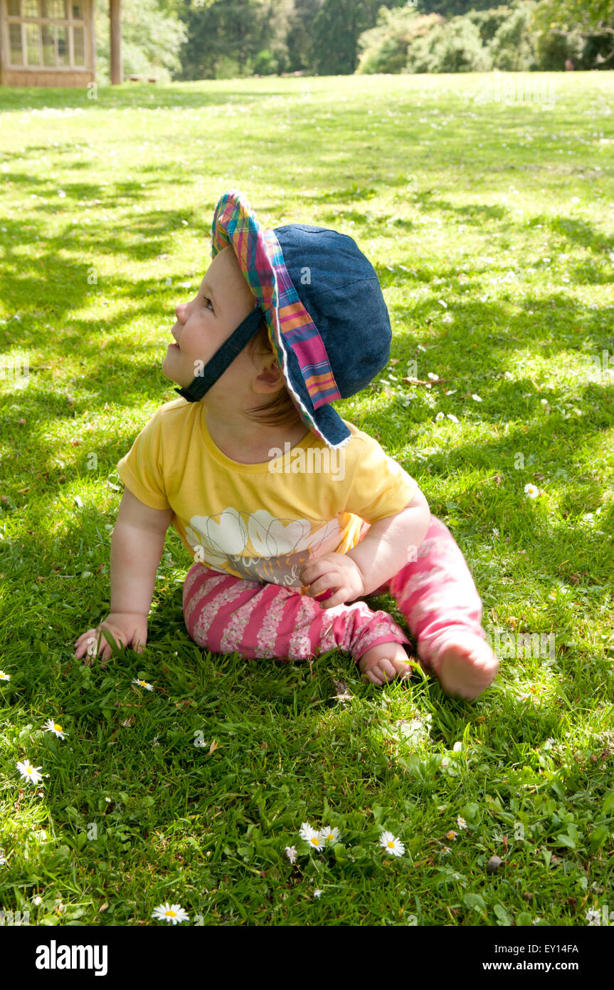 Little girl sitting on the grass Stock Photo - Alamy