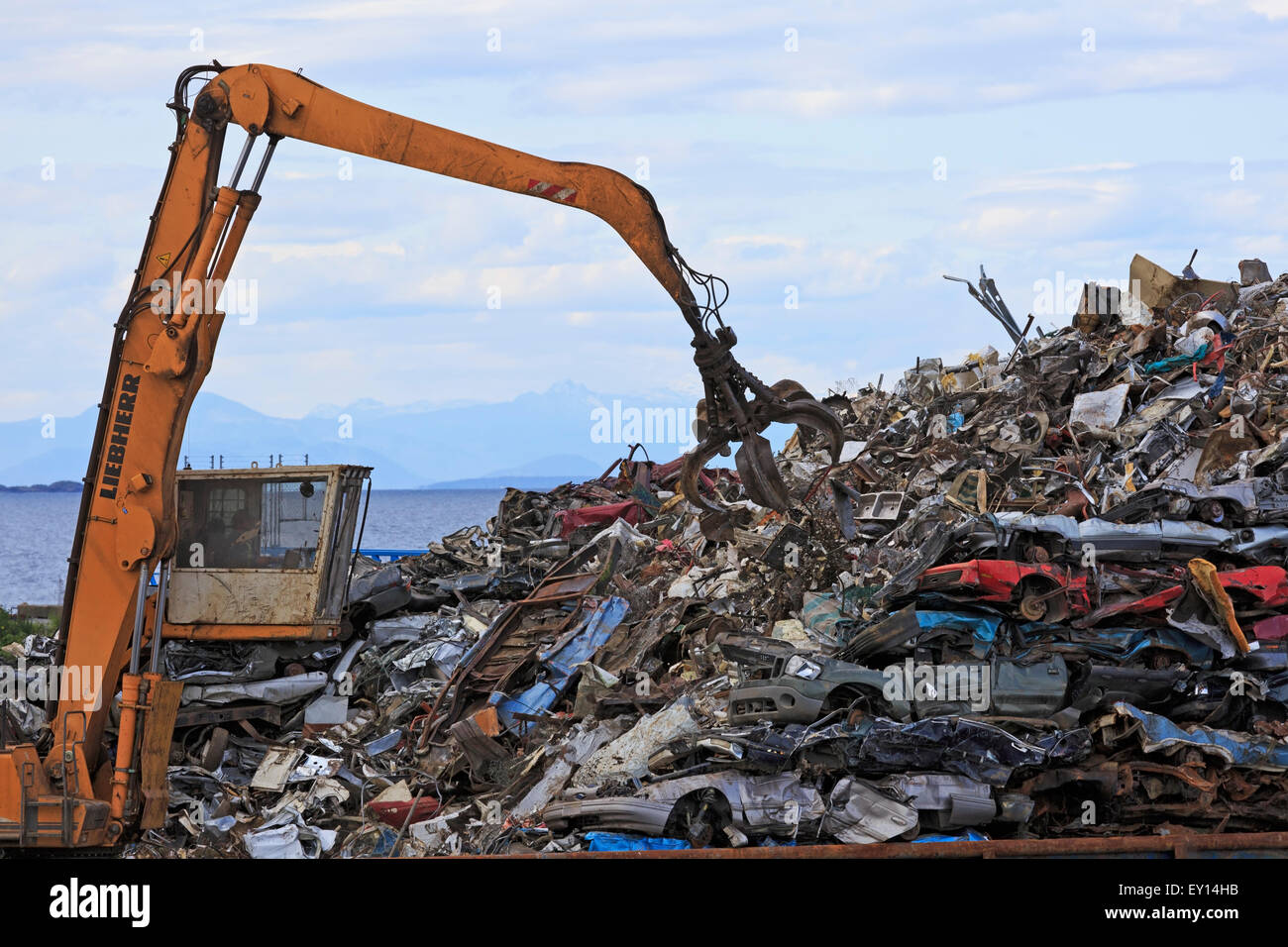 Machine loading scrap metal onto barge, Duke Point, Vancouver Island ...