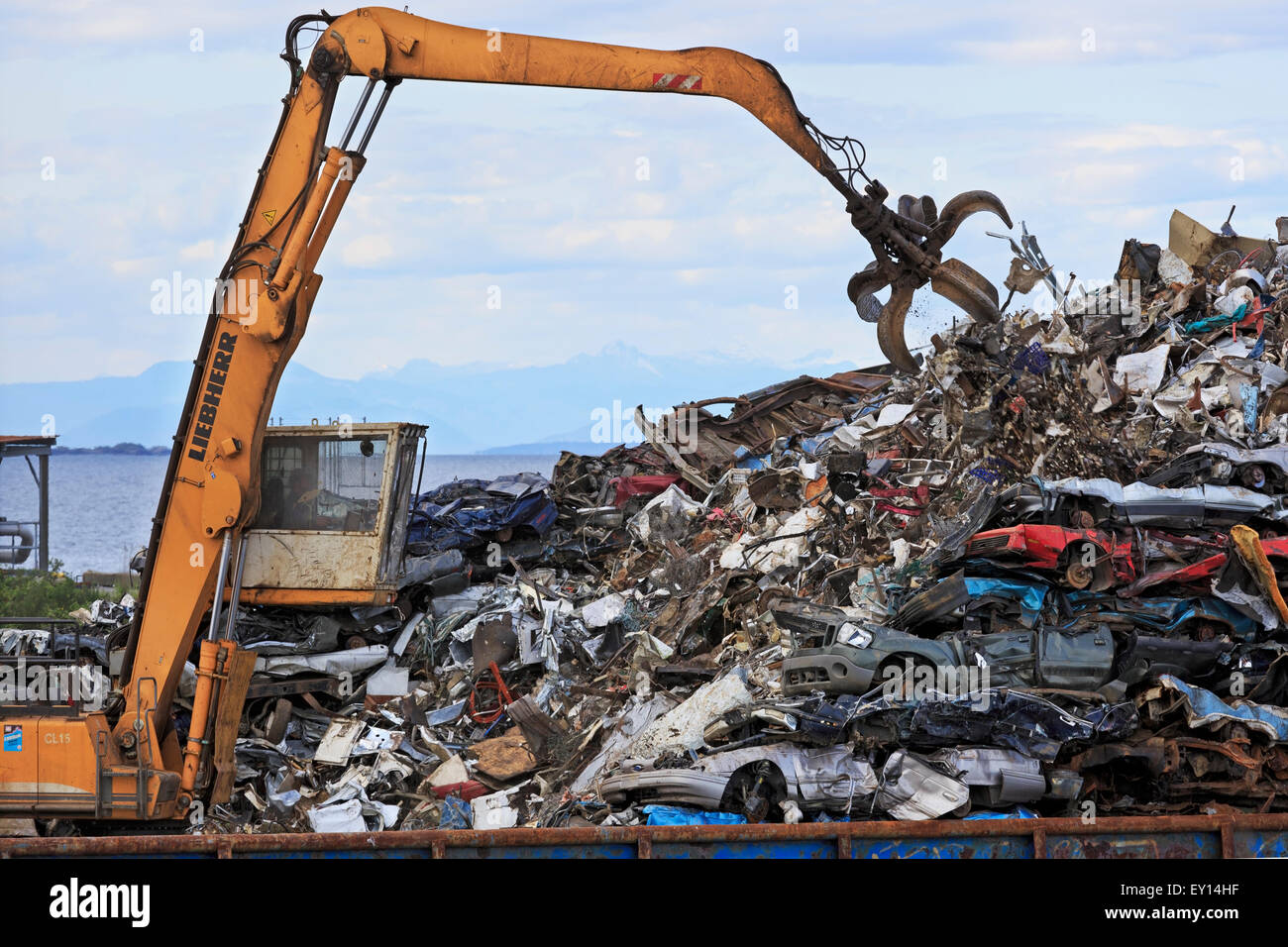 Machine loading scrap metal onto barge, Duke Point, Vancouver Island ...