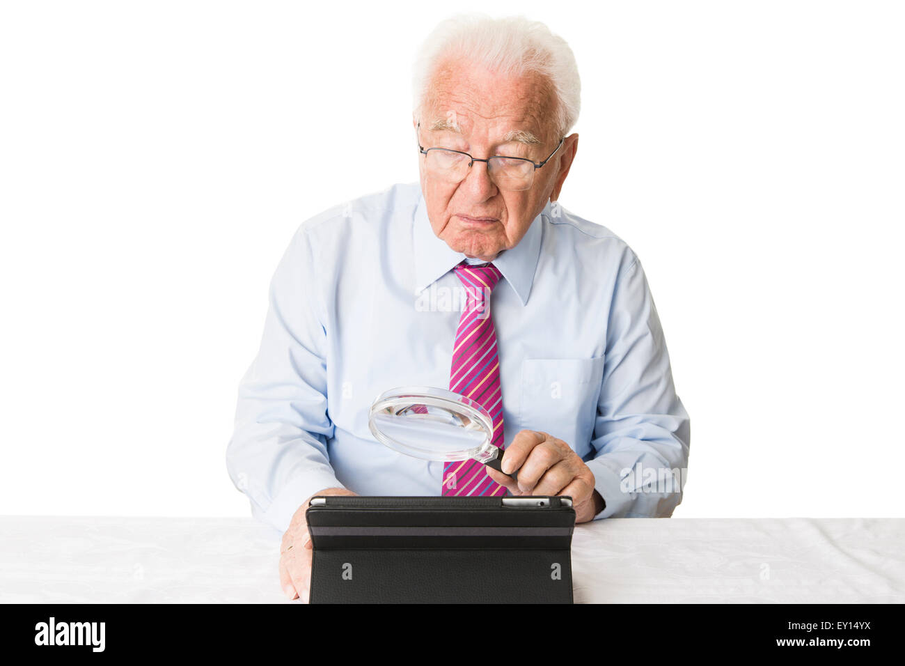 Senior using a tablet computer with a magnifying glass Stock Photo - Alamy