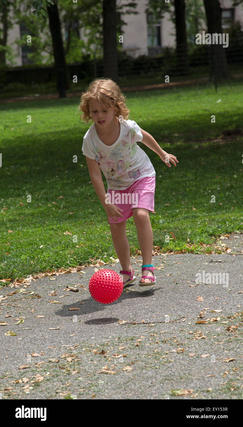Child playing with a ball in a park New York USA Stock Photo - Alamy