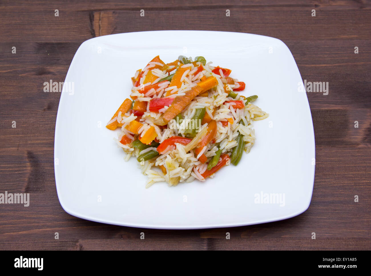 Rice with sauteed vegetables on wooden table Stock Photo - Alamy