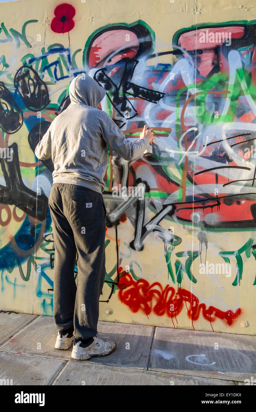 Graffiti wall with hoodie teen spraying Stock Photo - Alamy
