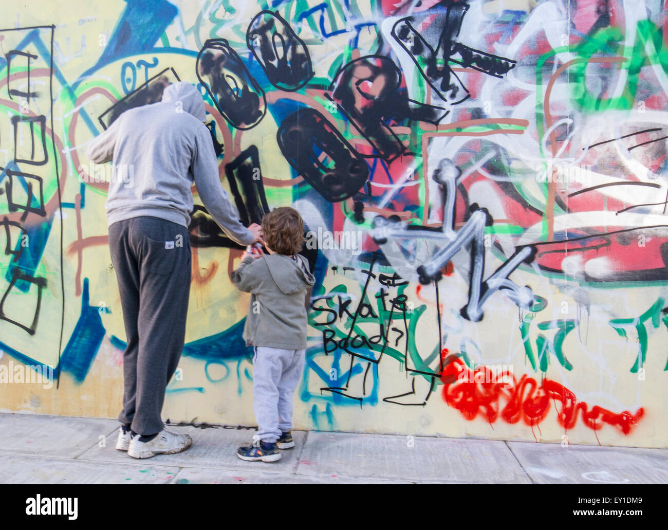 young boy trying to stop big brother spraying graffiti Stock Photo - Alamy