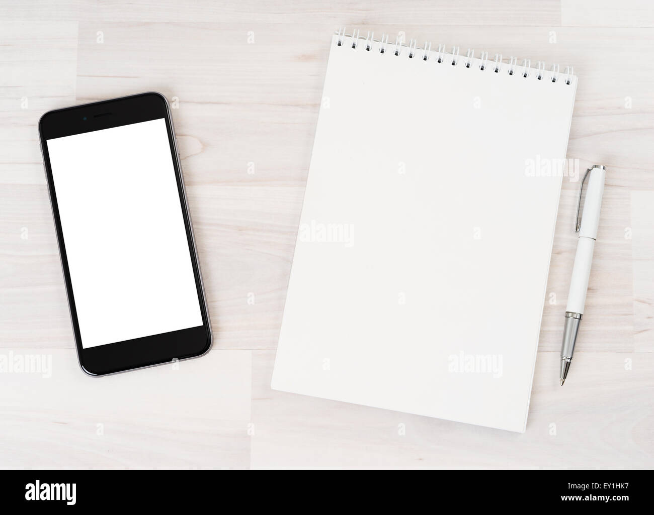 Smartphone with white screen isolated with a notebook on a light ...