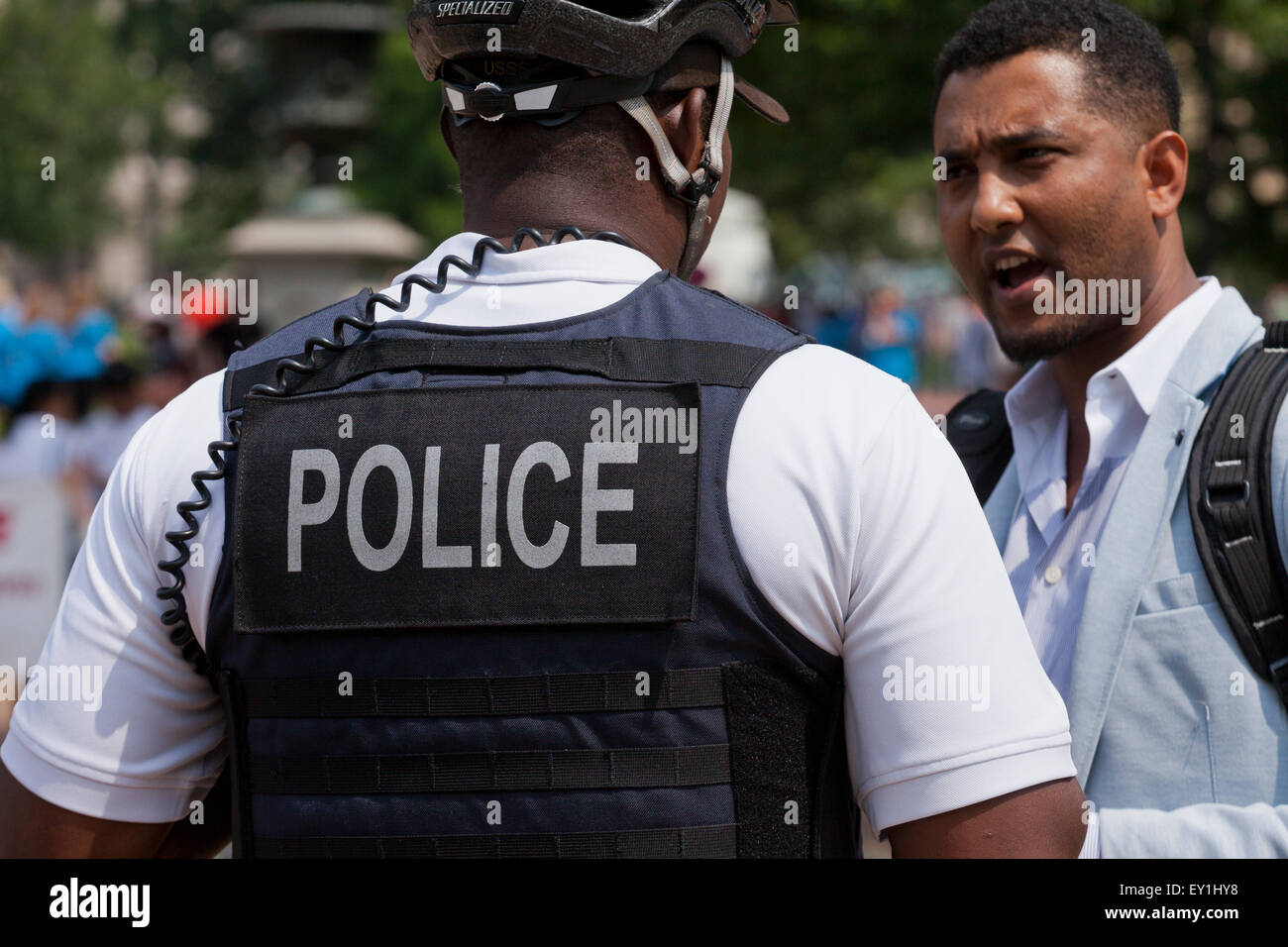 Policeman in bulletproof vest talking with man - USA Stock Photo - Alamy