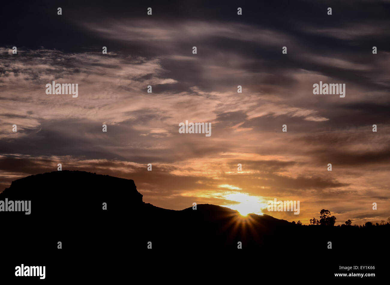 Sun behind a Mountain Silhouette Stock Photo - Alamy