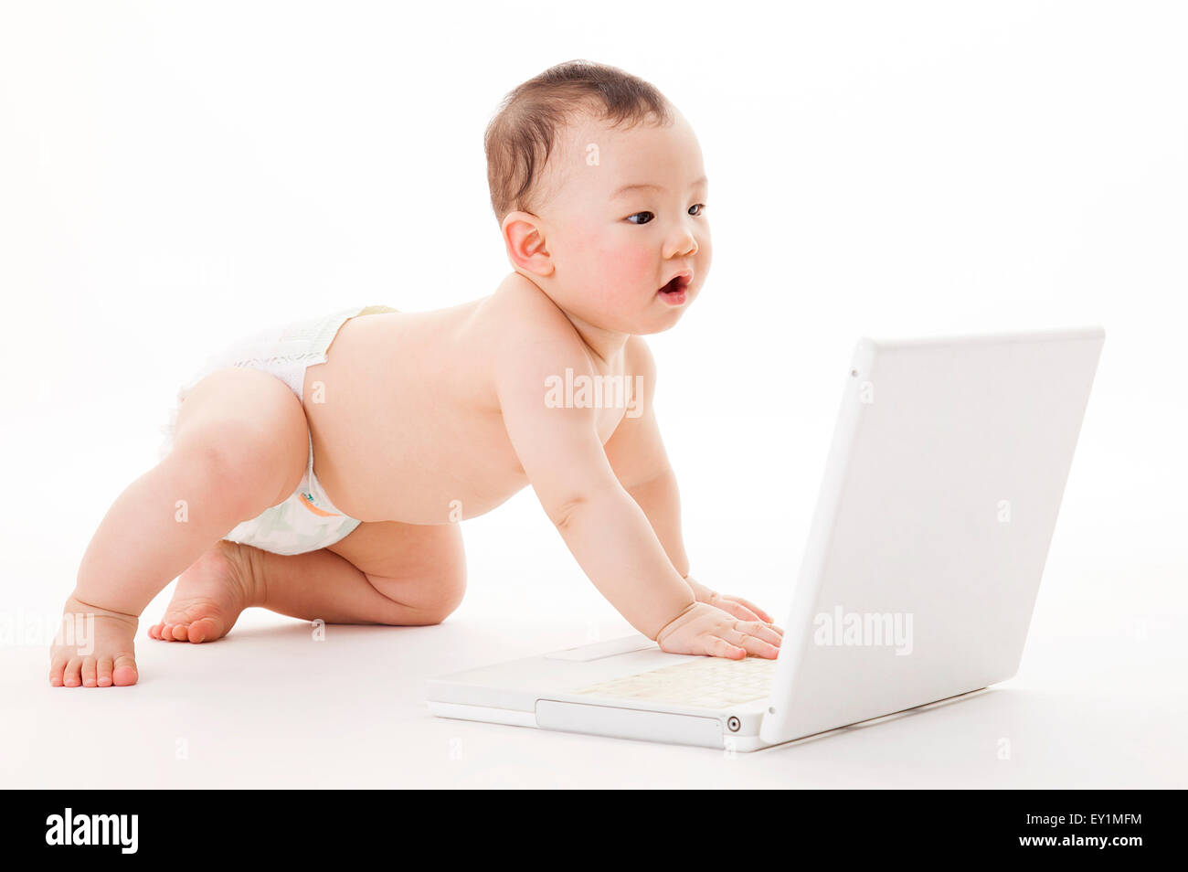 Baby boy touching laptop and looking away Stock Photo - Alamy