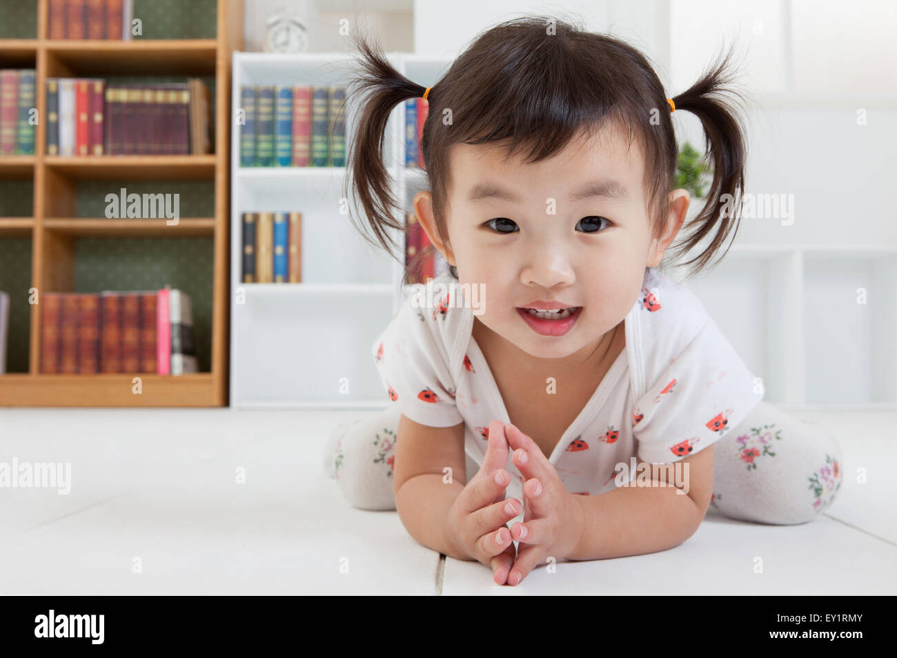 Little girl lying down on front and smiling happily Stock Photo - Alamy