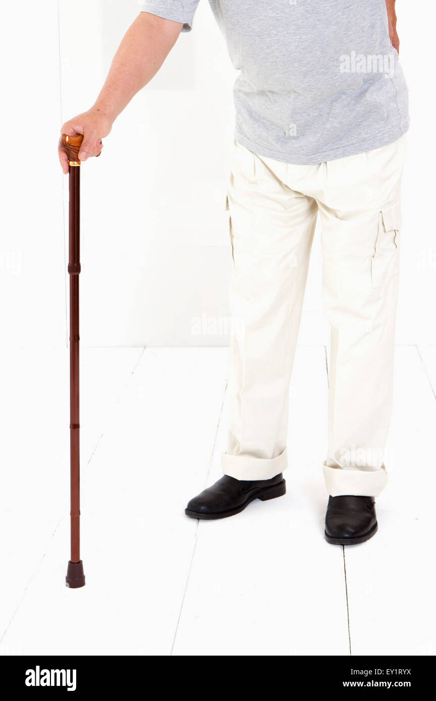 Senior man standing and holding a walking stick hi-res stock ...