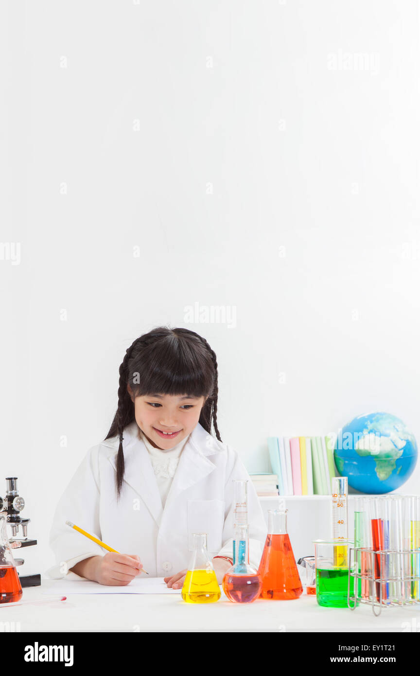Girl doing experiment and looking down with smile Stock Photo - Alamy