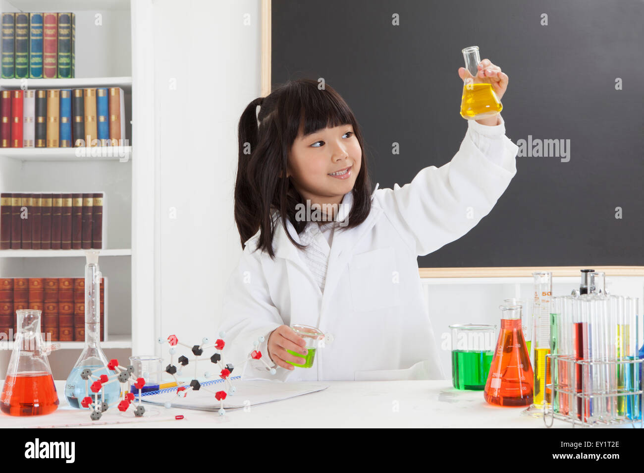 Girl doing experiment and looking away with smile Stock Photo - Alamy