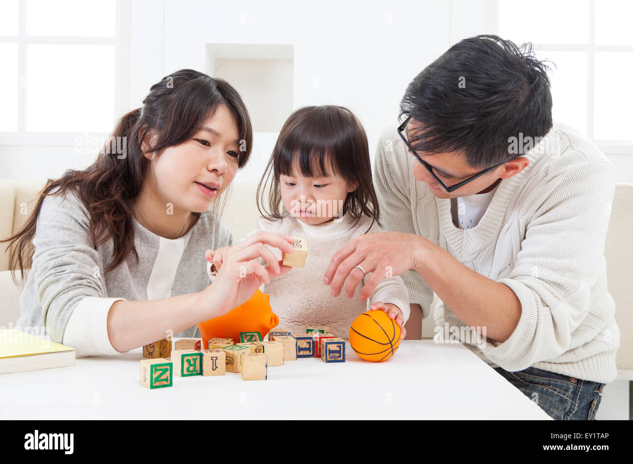 Family with one child playing with toys together Stock Photo - Alamy