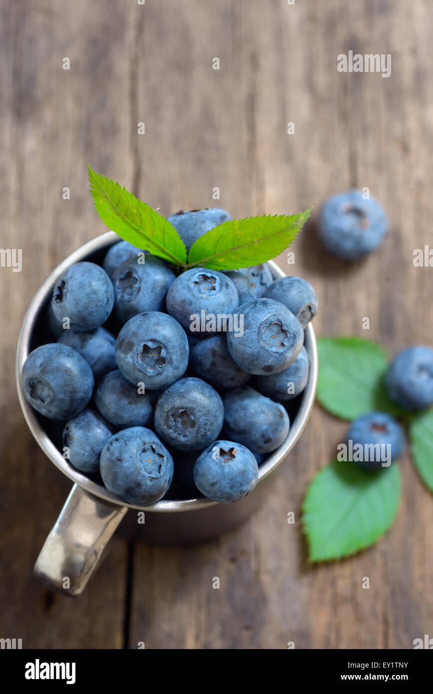 Metal cup and Blueberry on old wood Stock Photo - Alamy
