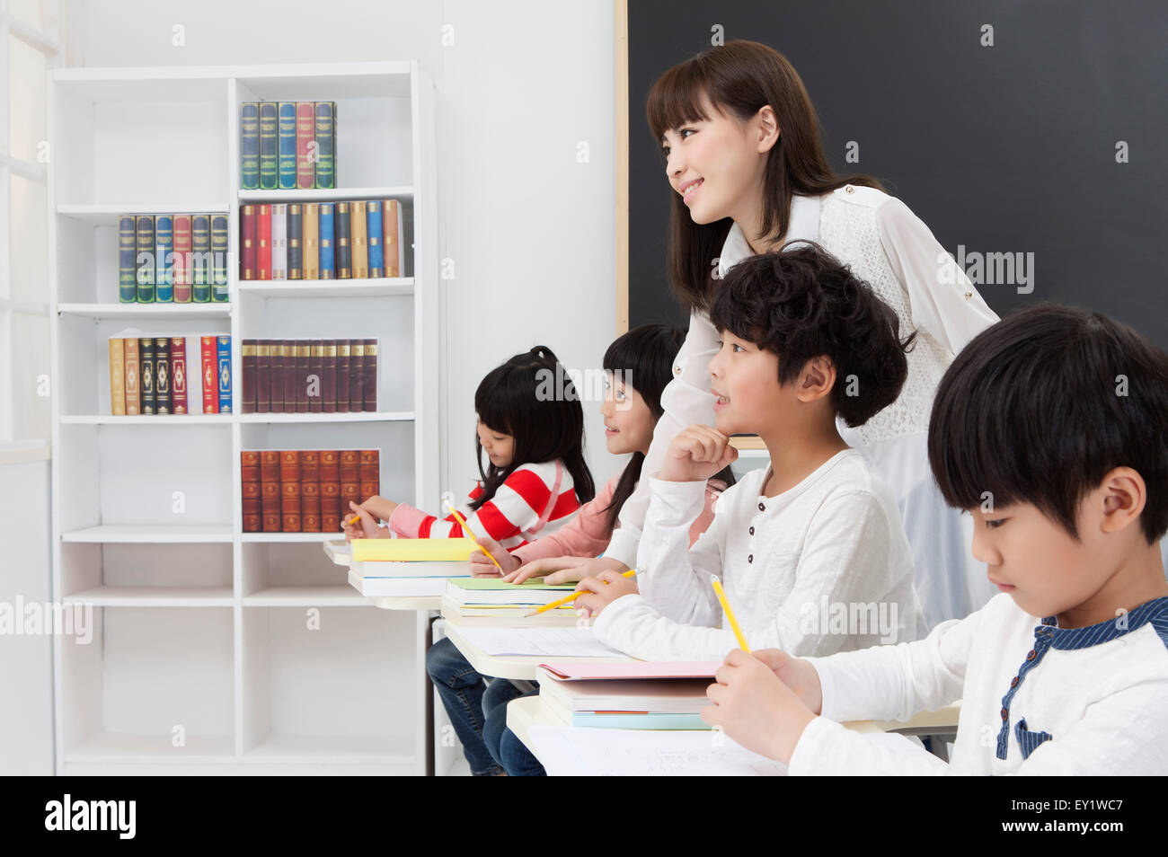 Young teacher teaching students in the classroom and smiling Stock ...
